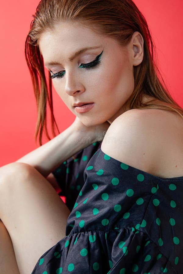 Young Beautiful Woman Wearing Black Dress In Green Polka Dots On Red