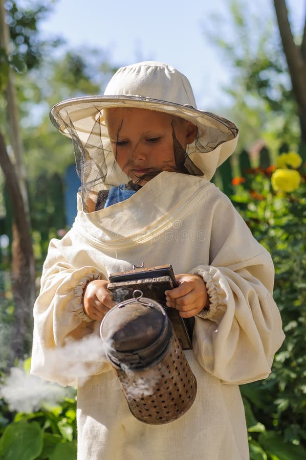 Young Beekeeper Boy Using a Smoker on Bee Yard Stock Photo - Image of ...