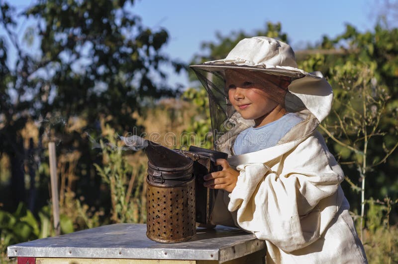 Young Beekeeper Boy Using a Smoker on Bee Yard Stock Photo - Image of ...