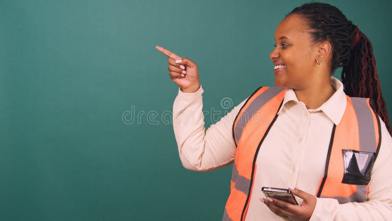 Young Black Construction Worker Points To Copy Space Smiling, Working ...