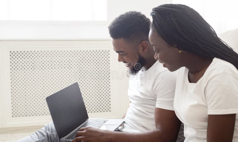 Young Black Couple Using Laptop with Black Screen at Home Stock Image ...