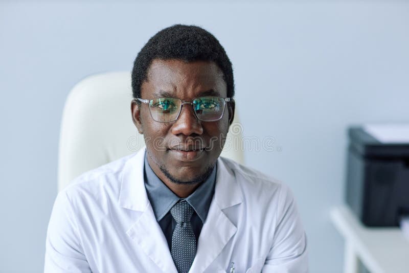 Young Black Doctor Looking at Camera Sitting at Desk Stock Image ...