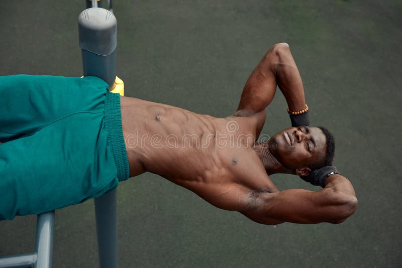 Young Black Man Doing Crunches Outdoors. he is in a Park. Stock Image ...