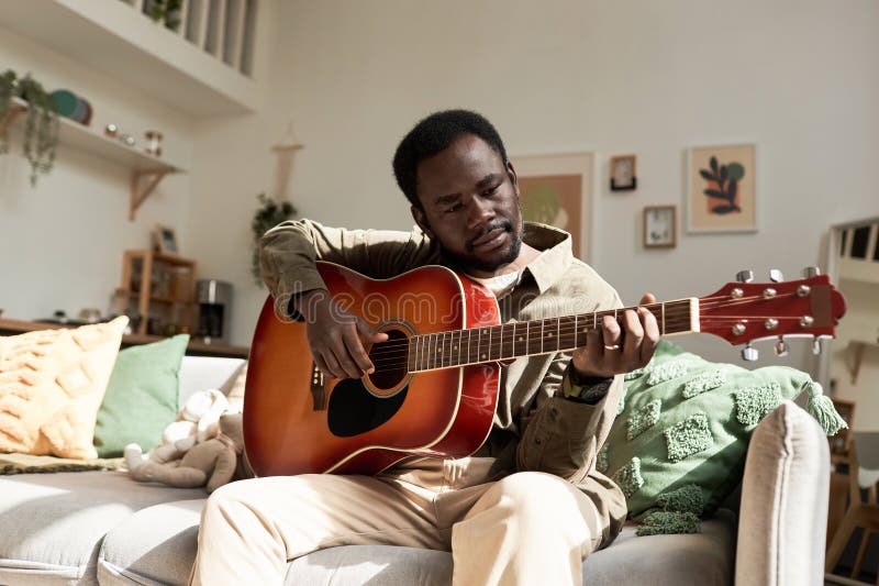 Young Black Man Playing Acoustic Guitar in Cozy Home Stock Photo ...