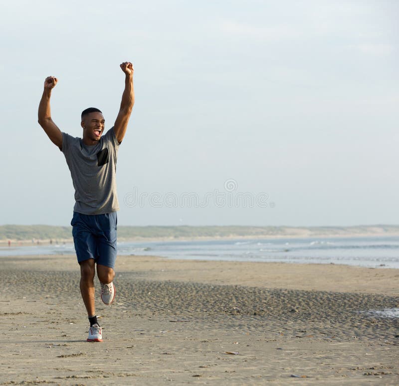 Young Black Man Running on Beach with Arms Raised Stock Photo - Image ...