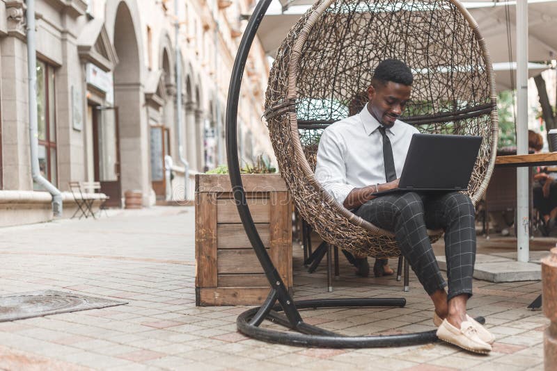 Young Black Man Using a Laptop Computer Outside a Cafe Stock Photo ...