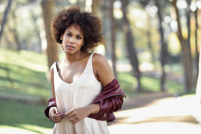 Young Black Woman With Afro Hairstyle Standing In Urban Background