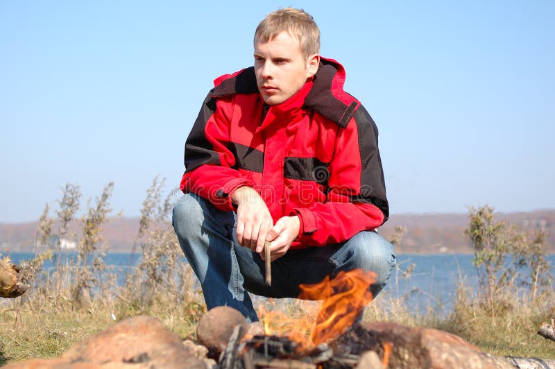 Young Blond Man in Red Jacket Sit Near Fire. Stock Image - Image of ...