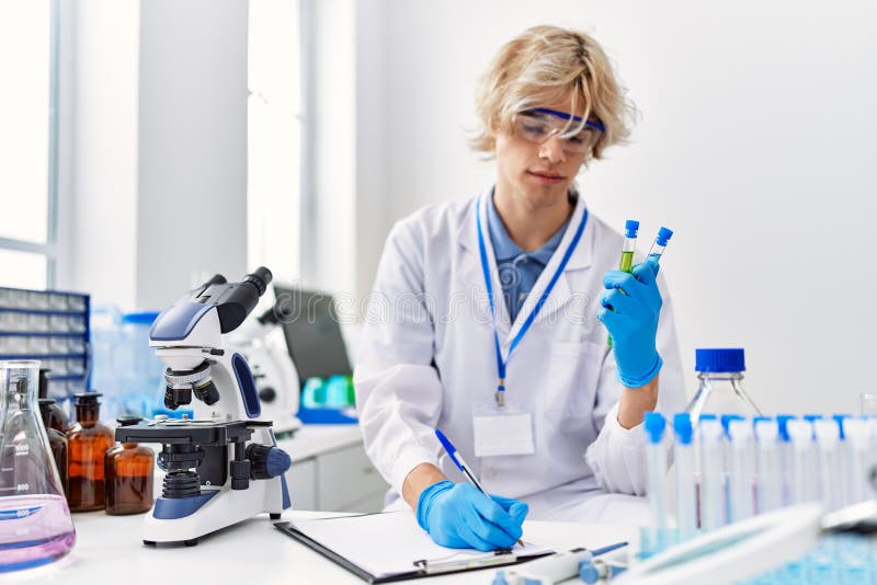 Young Blond Man Scientist Holding Test Tubes Writing on Document at ...