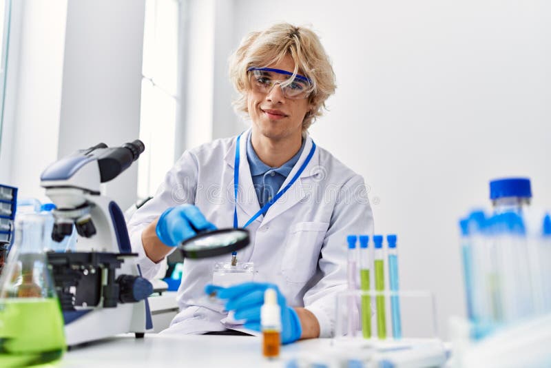 Young Blond Man Scientist Using Magnifying Glass at Laboratory Stock ...