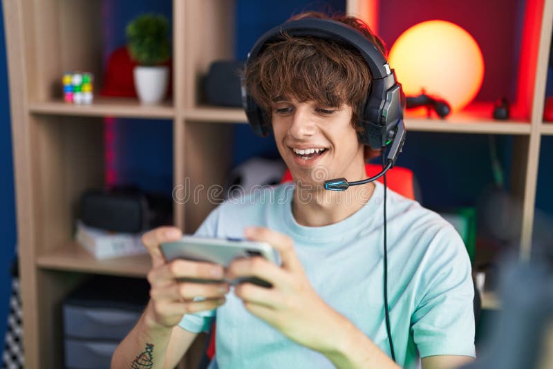 Young Blond Man Streamer Playing Video Game Using Smartphone at Gaming ... Young Blond Man Streamer Playing Video Game Using Smartphone at Gaming ...