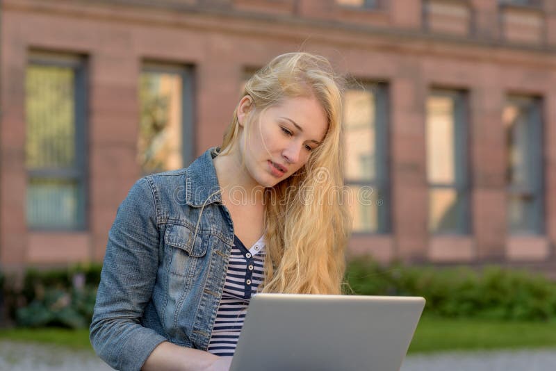 Young Blond Student Sitting on a Bench and Working on Her Laptop Stock ...