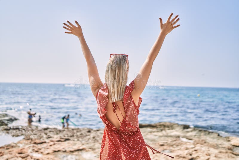 Young Blonde Girl on Back View Standing with Hands Raised Up at the ...