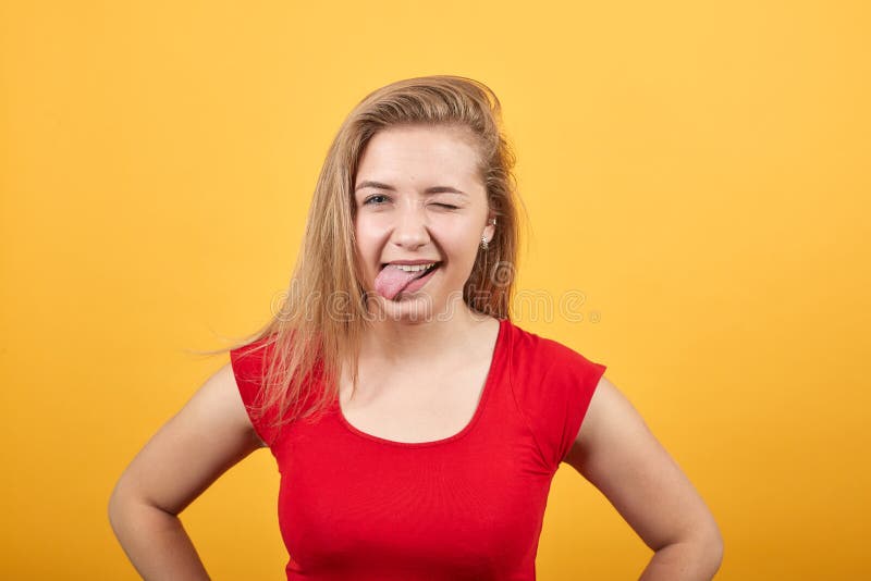 Young Blonde Girl In Red T Shirt Over Isolated Orange Background Shows