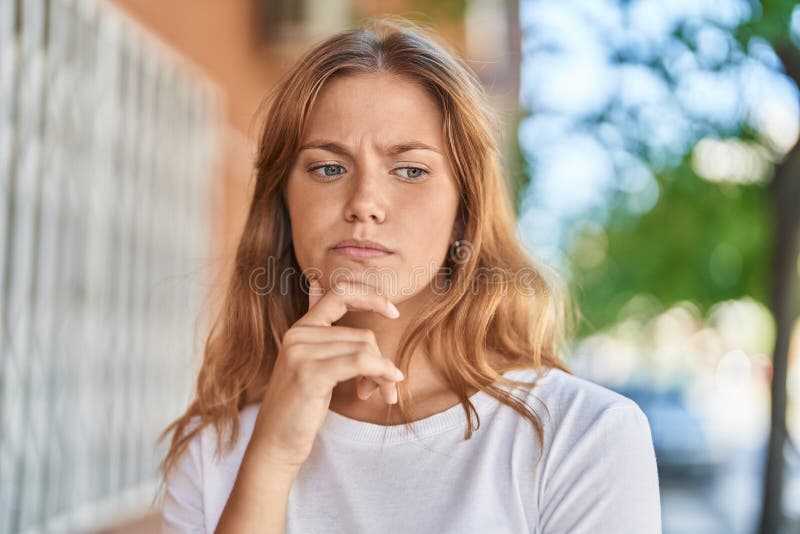 Young Blonde Girl Standing with Doubt Expression at Street Stock Photo ...