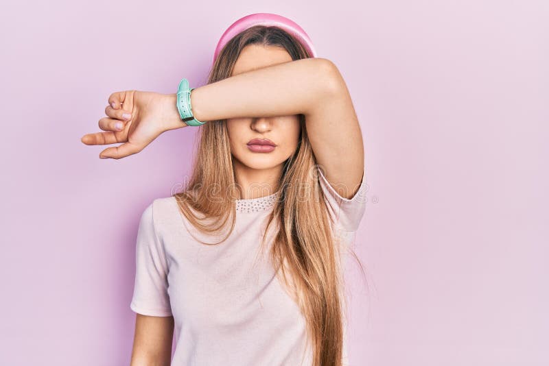Young Blonde Girl Wearing Casual Clothes Covering Eyes With Arm