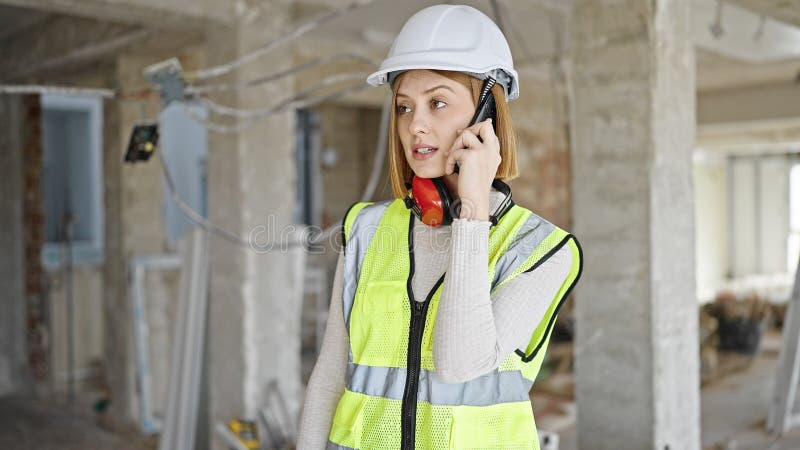 Young Blonde Woman Architect Talking on Smartphone at Construction Site ...