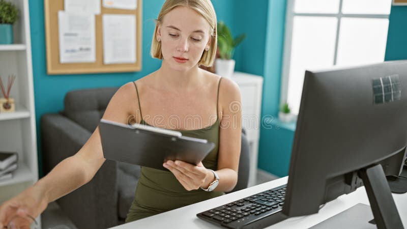 Young Blonde Woman Business Worker Using Computer Reading Document at ... Young Blonde Woman Business Worker Using Computer Reading Document at ...