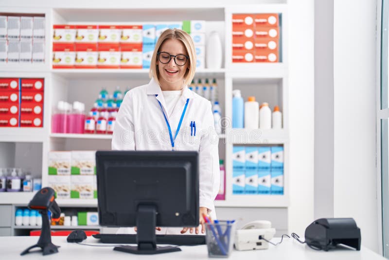 Young Blonde Woman Pharmacist Smiling Confident Using Computer at ...