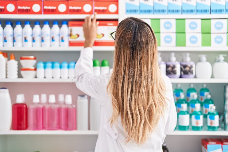 Young Blonde Woman Pharmacist Standing on Back View at Pharmacy Stock ...