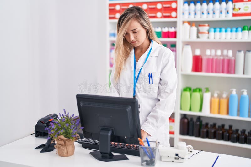 Young Blonde Woman Pharmacist Using Computer at Pharmacy Stock Image ...