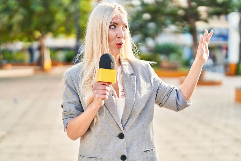 Young Blonde Woman Reporter Working Using Microphone at Park Stock ...