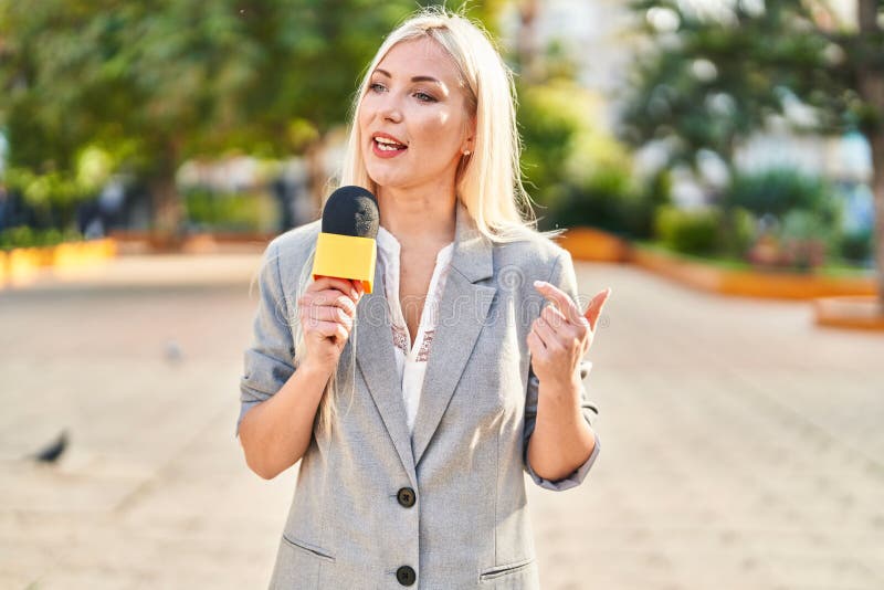 Young Blonde Woman Reporter Working Using Microphone at Park Stock ...