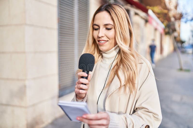 Young Blonde Woman Reporter Working Using Microphone Reading Notebook ...