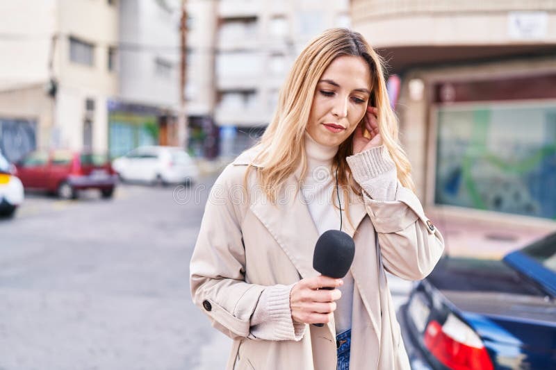 Young Blonde Woman Reporter Working Using Microphone at Street Stock ...