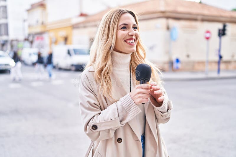 Young Blonde Woman Reporter Working Using Microphone at Street Stock ...