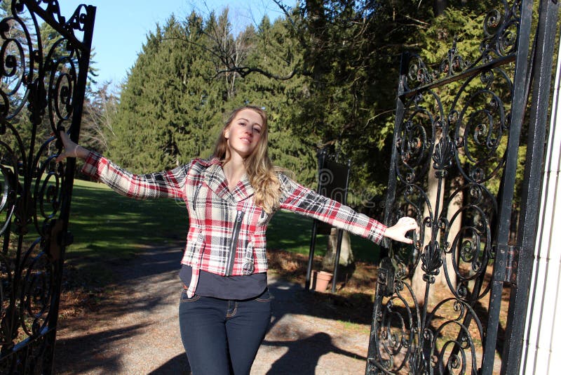Young Blonde Woman Standing at Open Gates Stock Photo - Image of ...