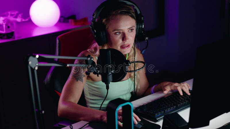 Young Blonde Woman Streamer Playing Video Game Using Computer at Gaming ...