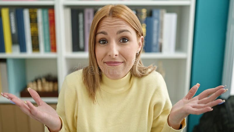 Young Blonde Woman Student Sitting with I Dont Know Expression at ...