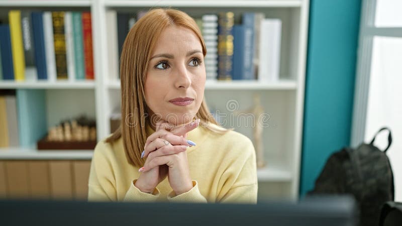 Young Blonde Woman Student Using Computer with Doubt Expression at ...