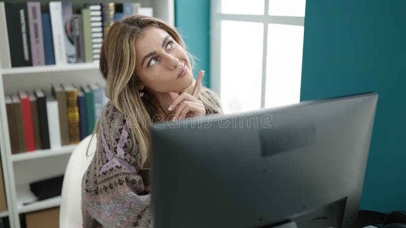 Young Blonde Woman Student Using Computer Studying with Doubt ...
