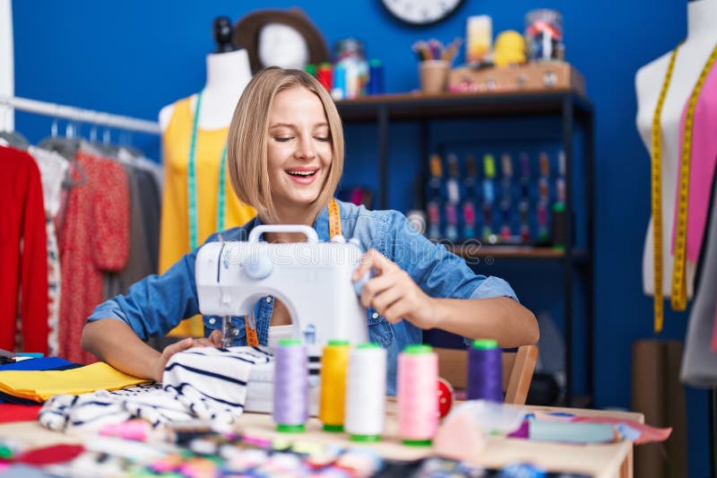 Young Blonde Woman Tailor Smiling Confident Using Sewing Machine at ...