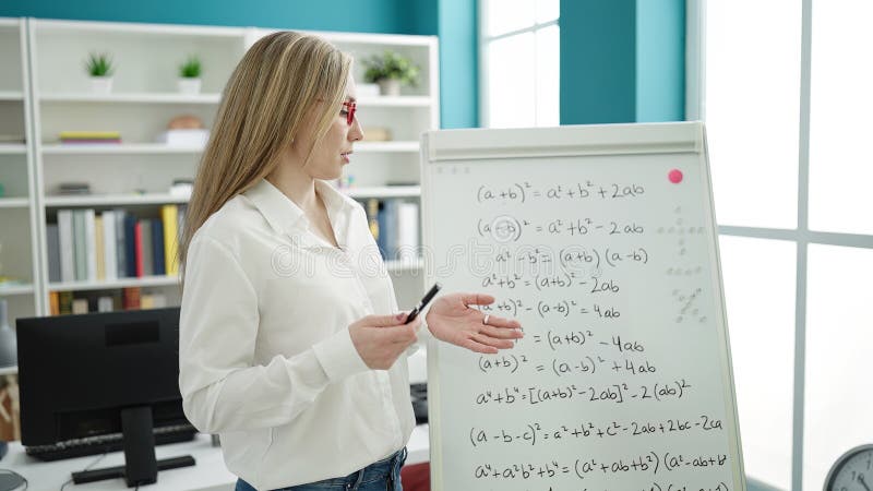 Young Blonde Woman Teacher Explaining Maths Exercise at Library ...