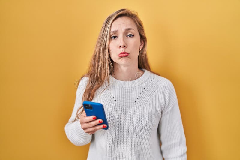 Young Blonde Woman Using Smartphone Typing Message Depressed and Worry ...