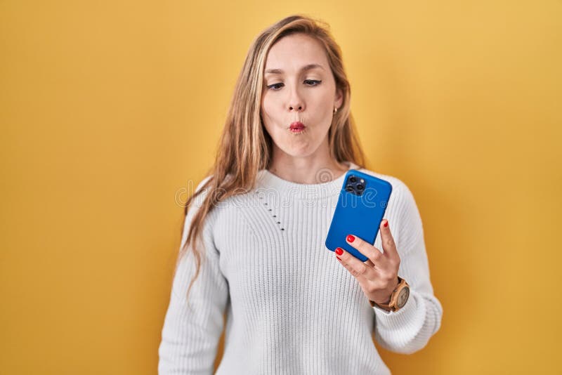 Young Blonde Woman Using Smartphone Typing Message Making Fish Face ...