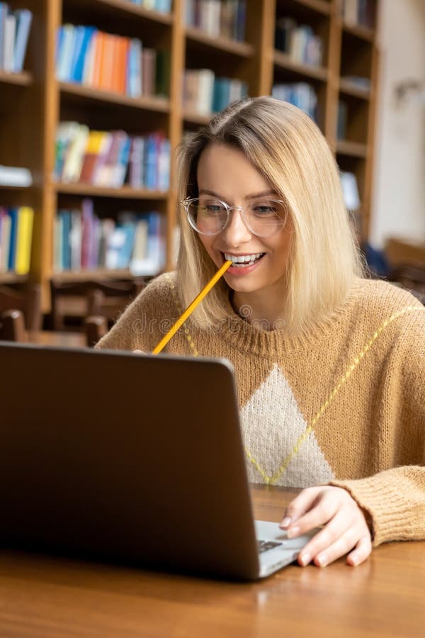 Young Blonde Woman Working on a Laptop in the Library Stock Photo ...