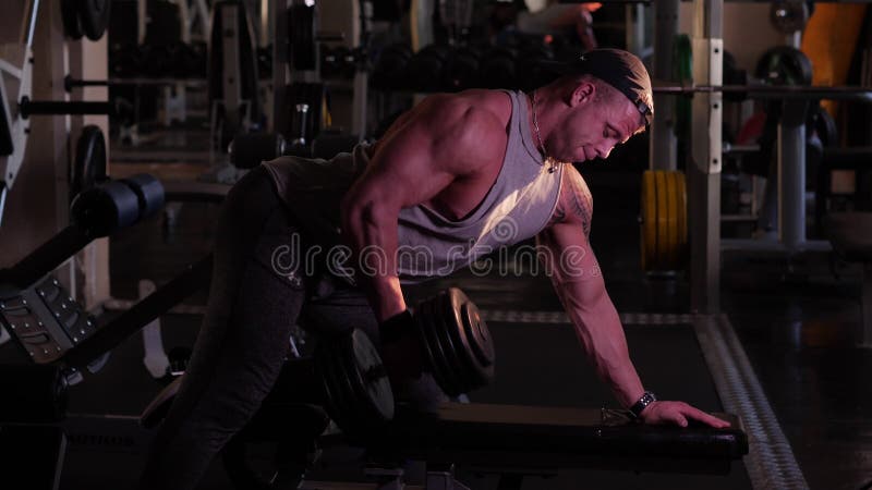 A Young Bodybuilder Plays Sports on a Sunny Day by the River and Does ...