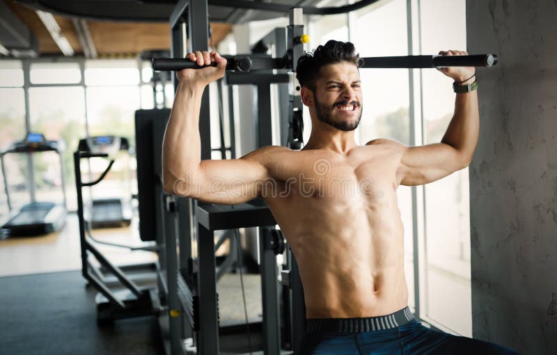 Young Bodybuilder Training in Gym on Machine Stock Photo - Image of ...