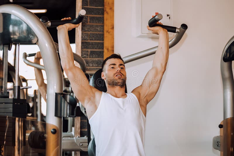 Young Bodybuilder Training in Gym on Machine Stock Image - Image of ...