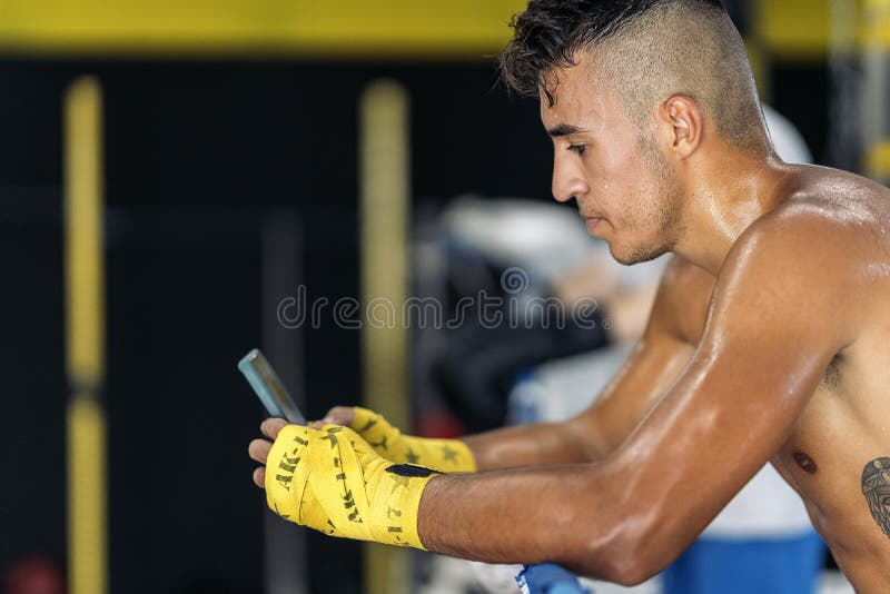 Young Boxer Leaning on the Ropes of the Ring Using His Phone after ...