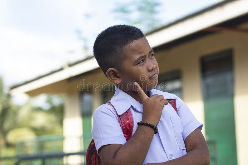 A Young Boy with a Backpack Contemplating while Standing Outside His ...
