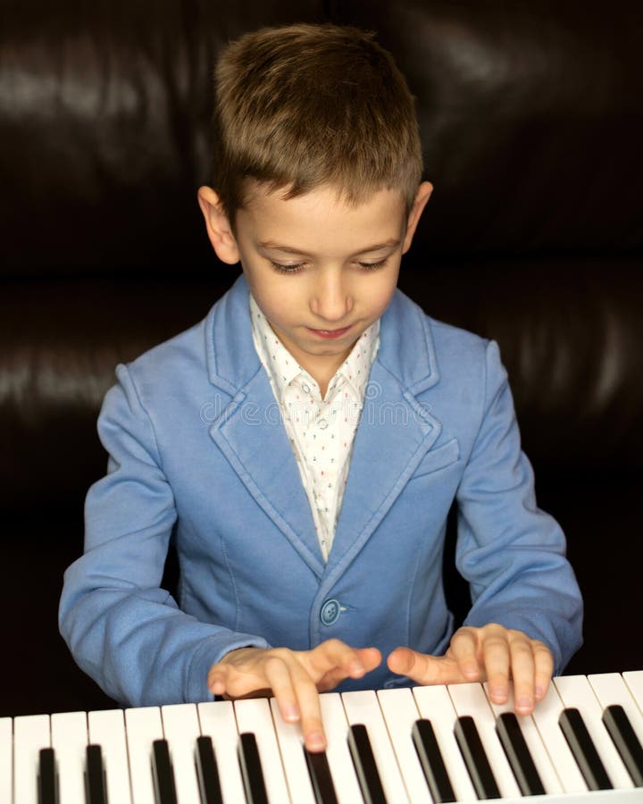 Young Boy in Blue Blazer Playing Piano with Focus Stock Photo - Image ...