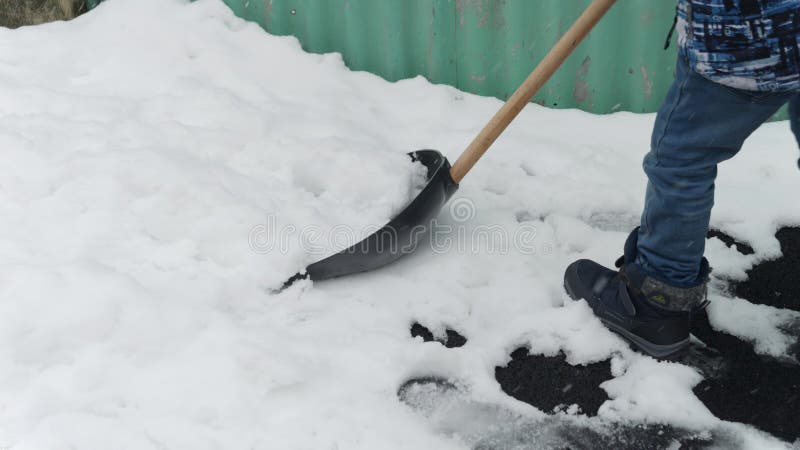 Young Boy Clearing Snow from the Backyard or Walkway Using a Shovel ... Young Boy Clearing Snow from the Backyard or Walkway Using a Shovel ...