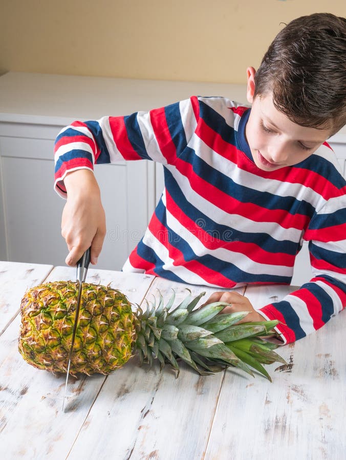 Young Boy Cutting a Fresh Pineapple Stock Photo - Image of cooking ...