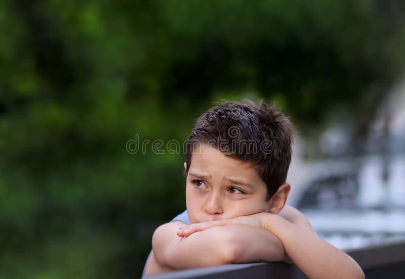 Young Boy Deep in Thoughts stock photo. Image of greenery - 193079426