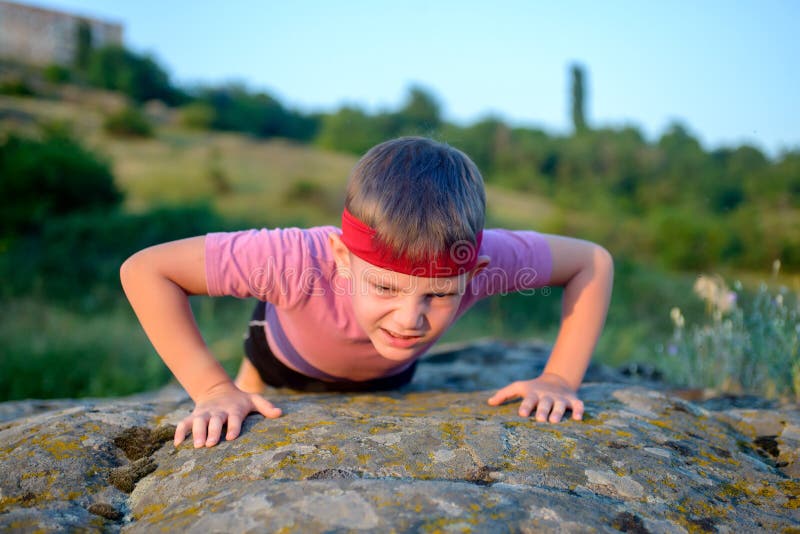 Young Boy Doing Push-ups on a Rock Stock Photo - Image of active ...